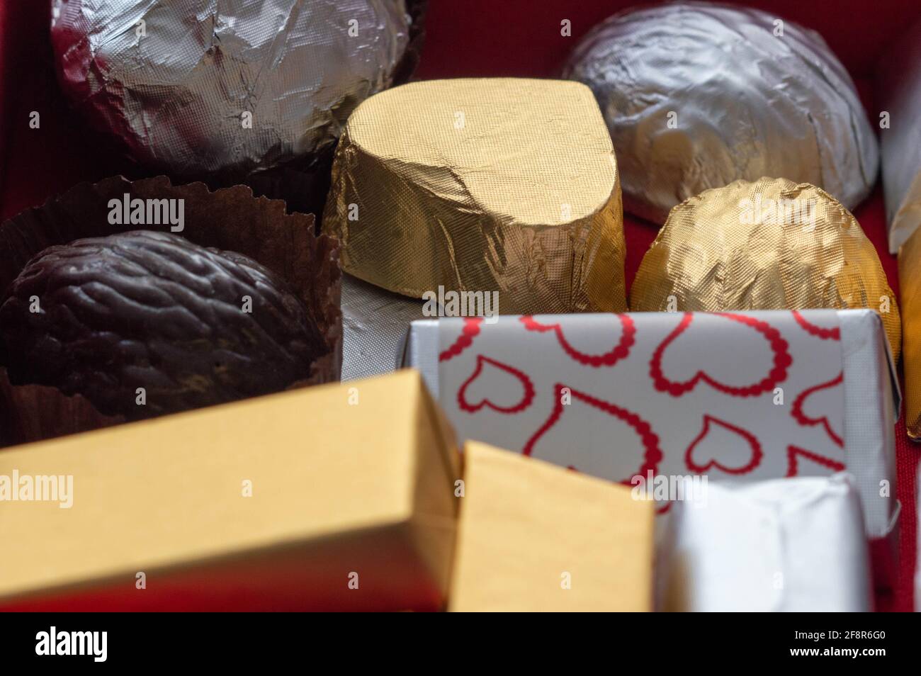 Chocolate candies in an open box by a group Stock Photo - Alamy