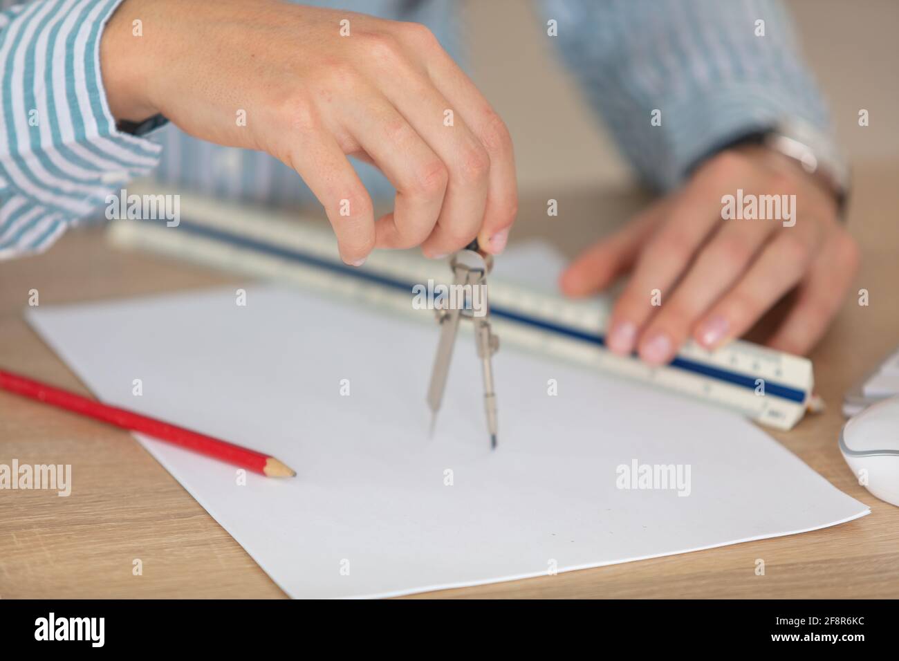 close view of hands using a compass at a desk Stock Photo - Alamy