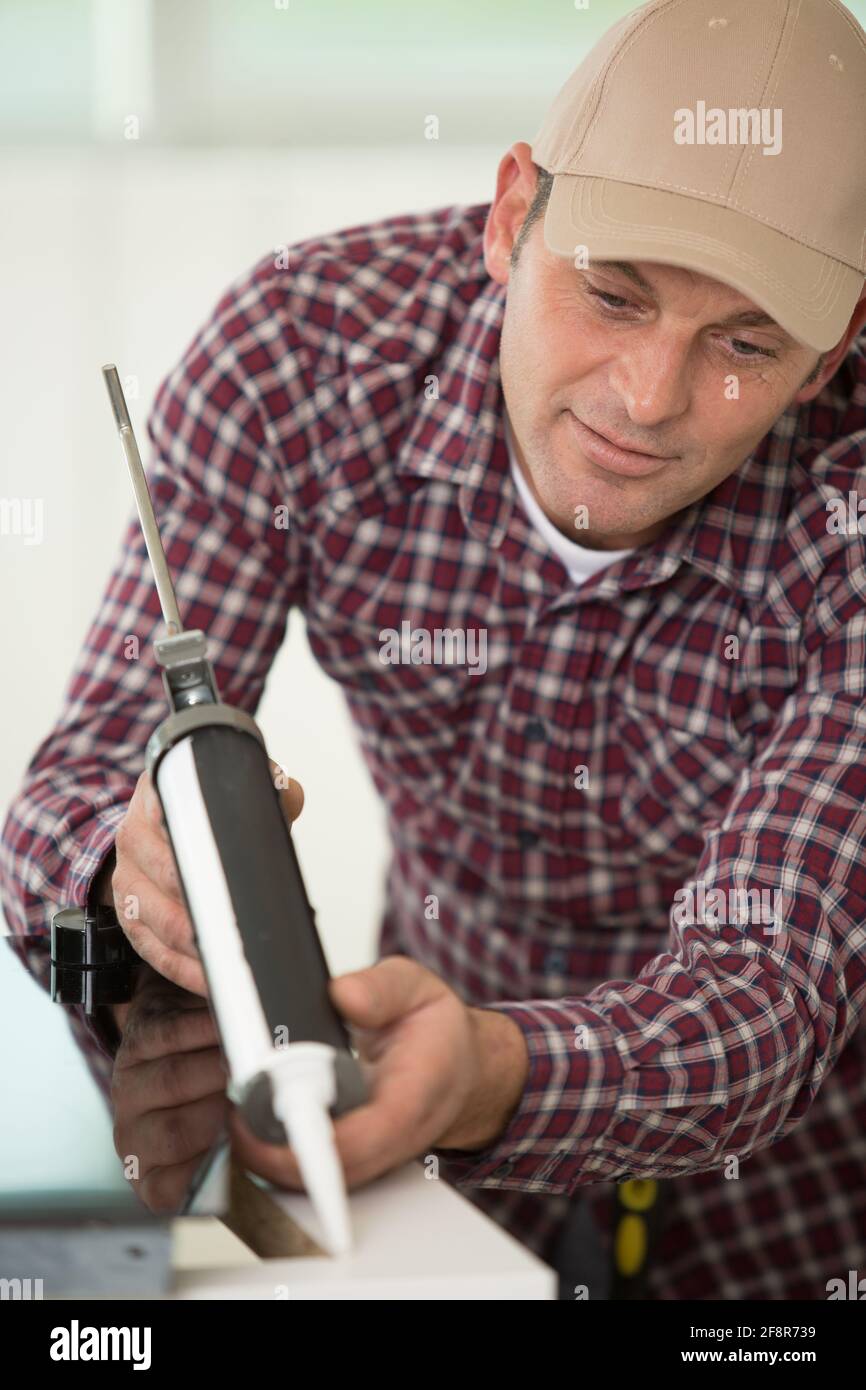 construction workers installing windows and using silicon Stock Photo ...