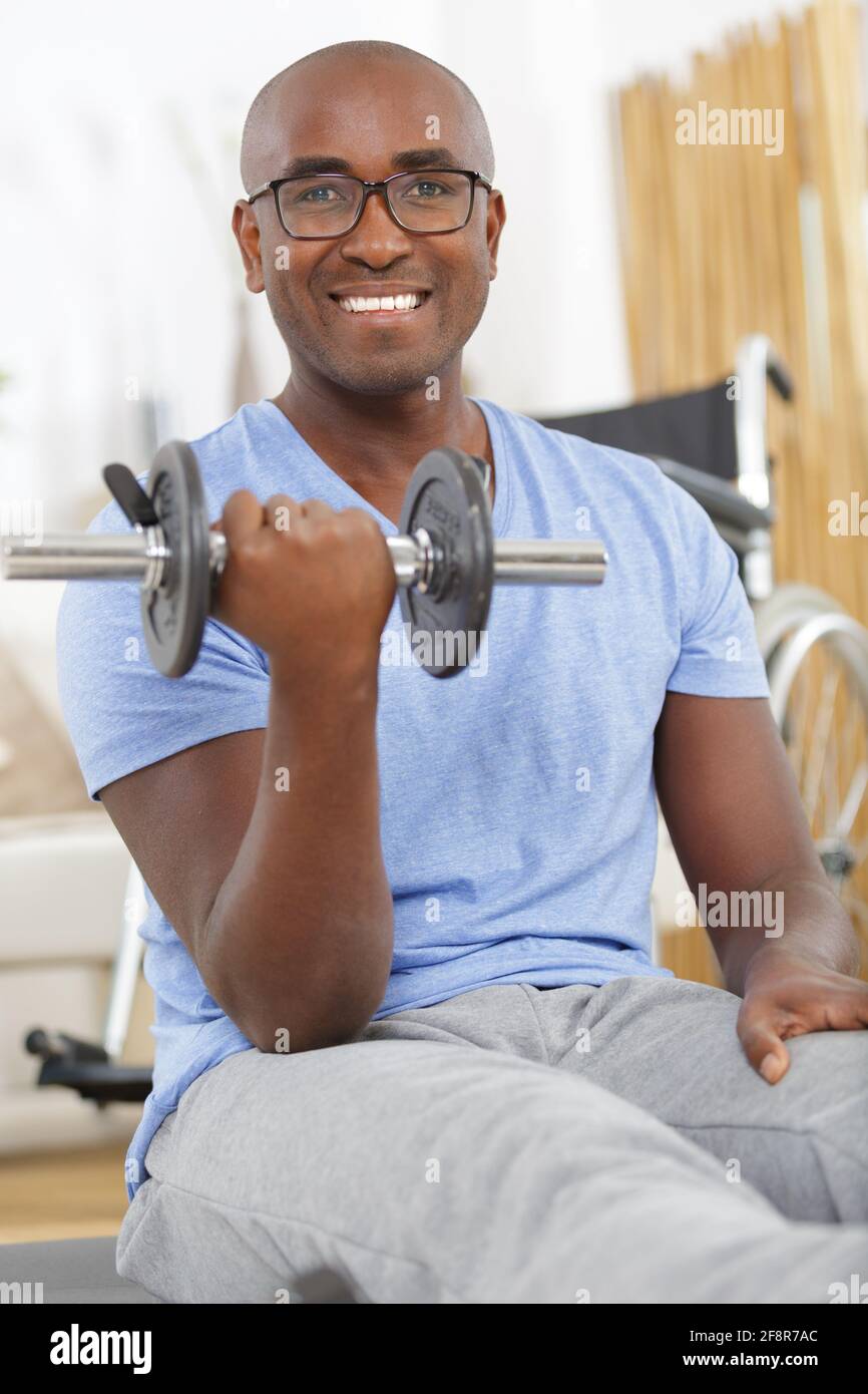 happy disabled man in wheelchair train with bar-bell Stock Photo - Alamy
