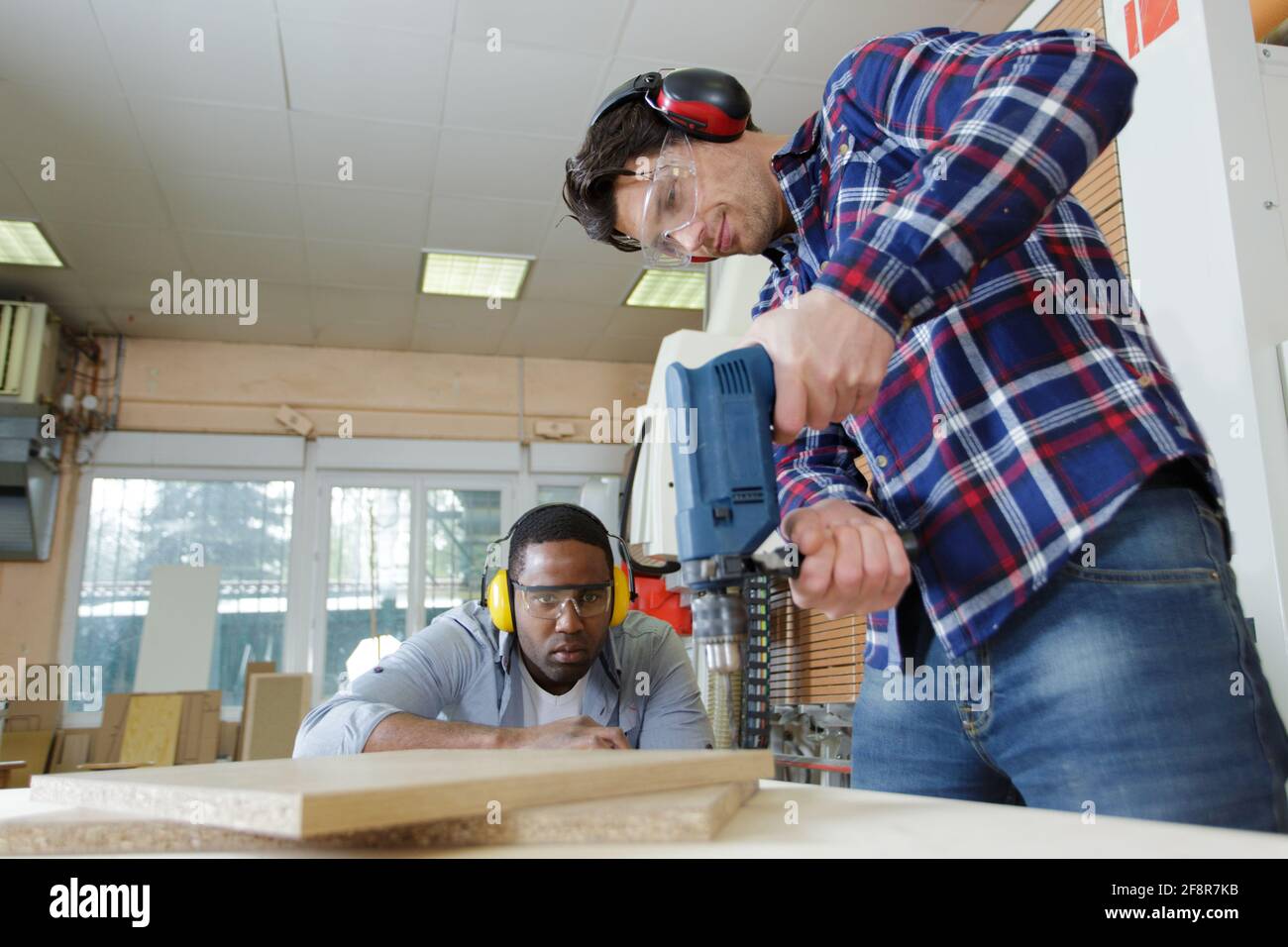 male worker behind drilling machine Stock Photo - Alamy
