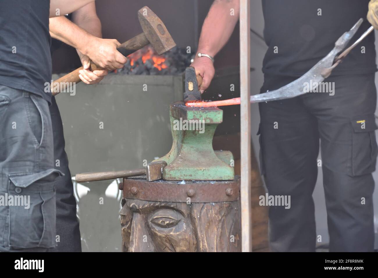 blacksmiths use hammers to form an iron detail Stock Photo - Alamy