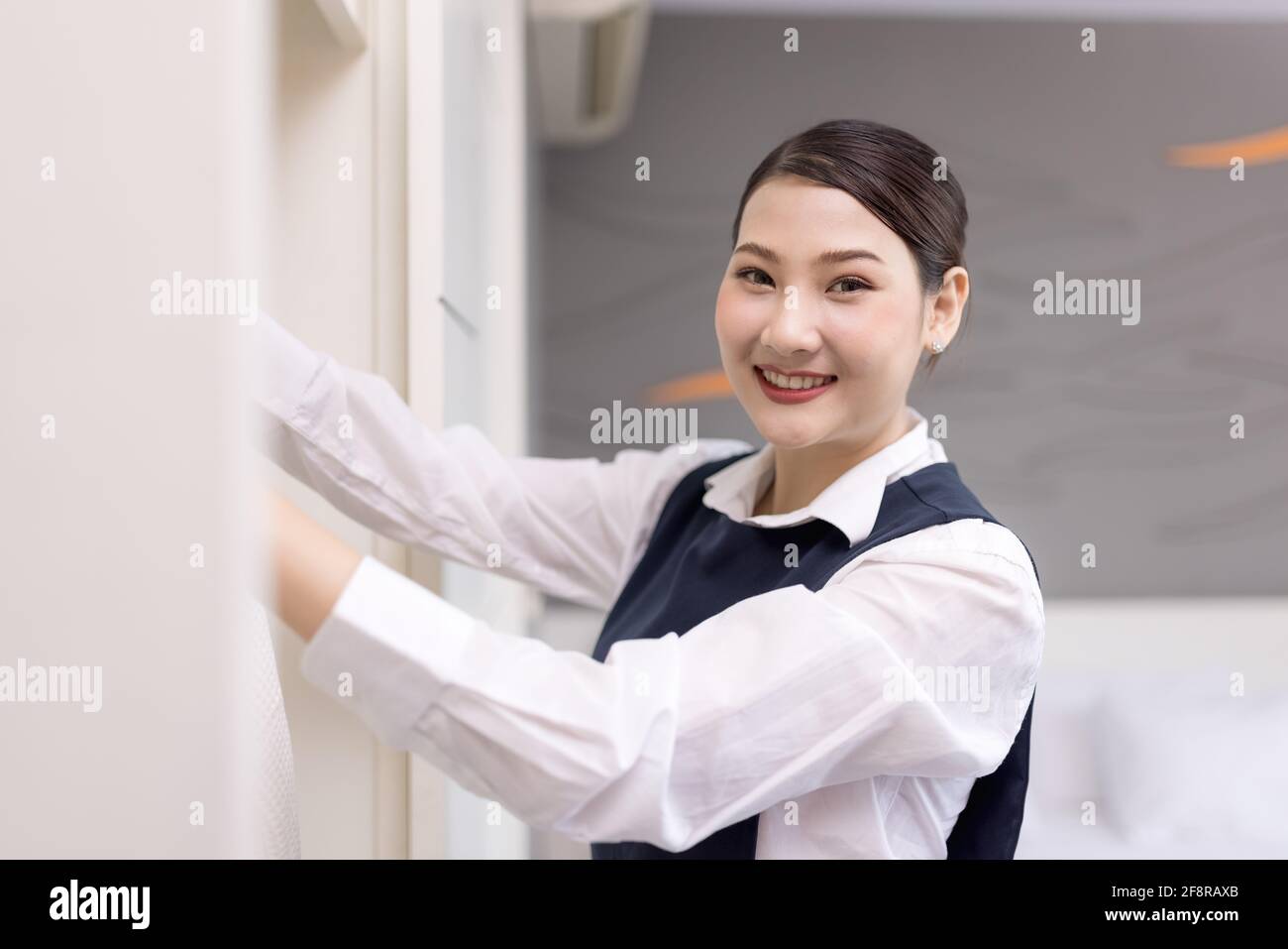 Smiling maid with White bathrobe with hanger in wardrobe, The concept ...