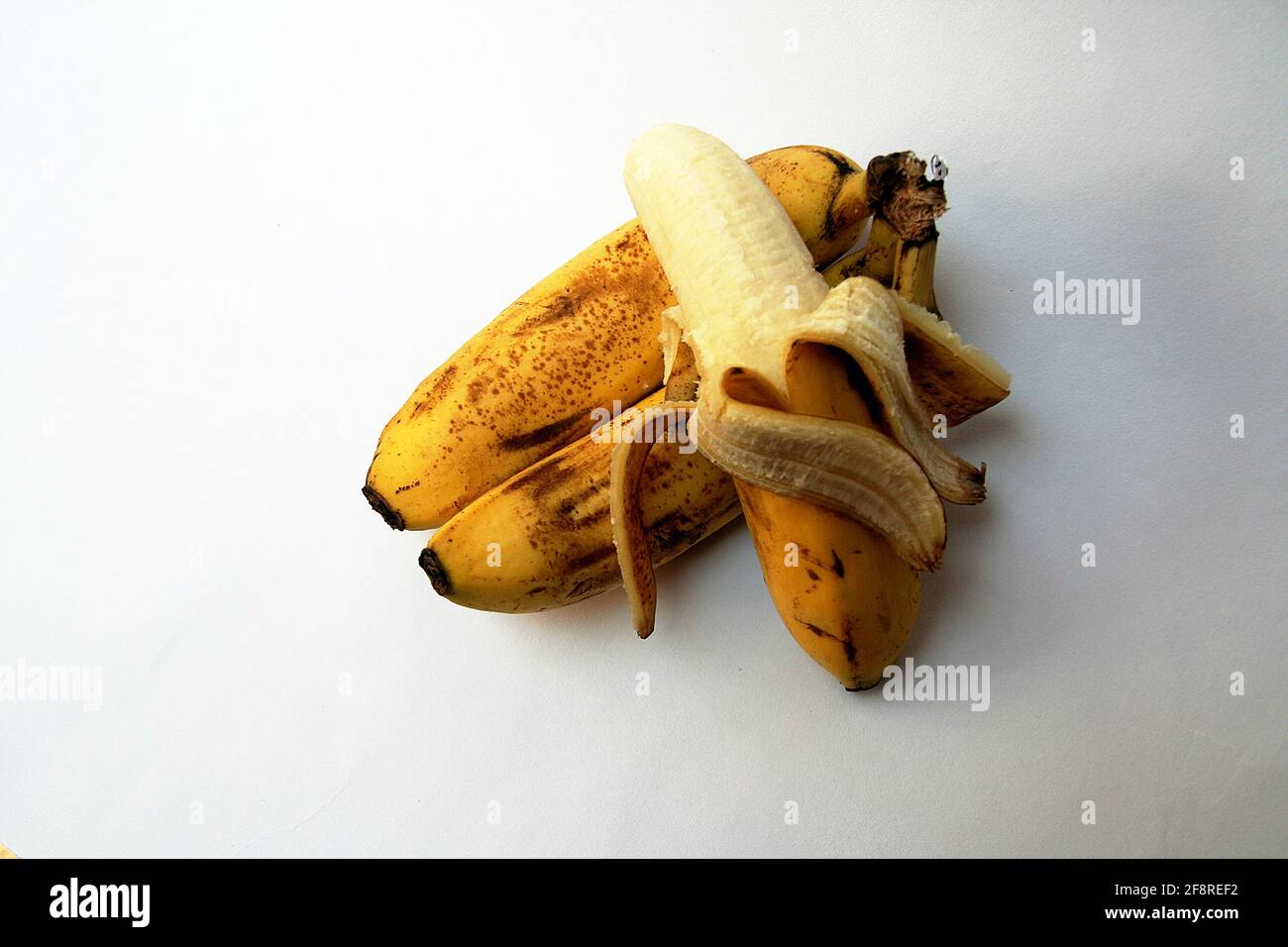 Closeup shot of fresh whole and peeled ripe banana isolated on a white ...