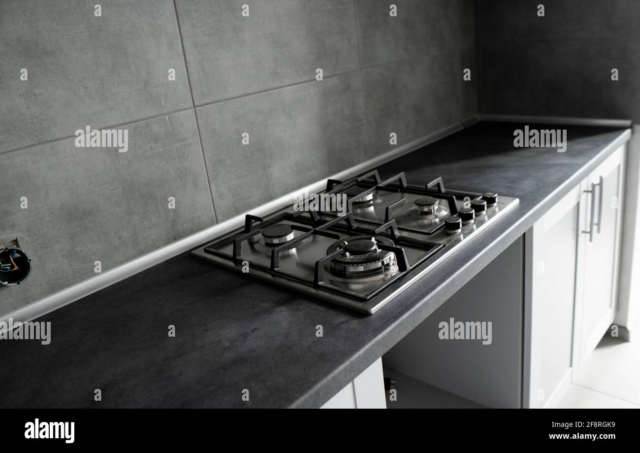 Stainless grey metal kitchen gas stove installed on a the kitchen with ...