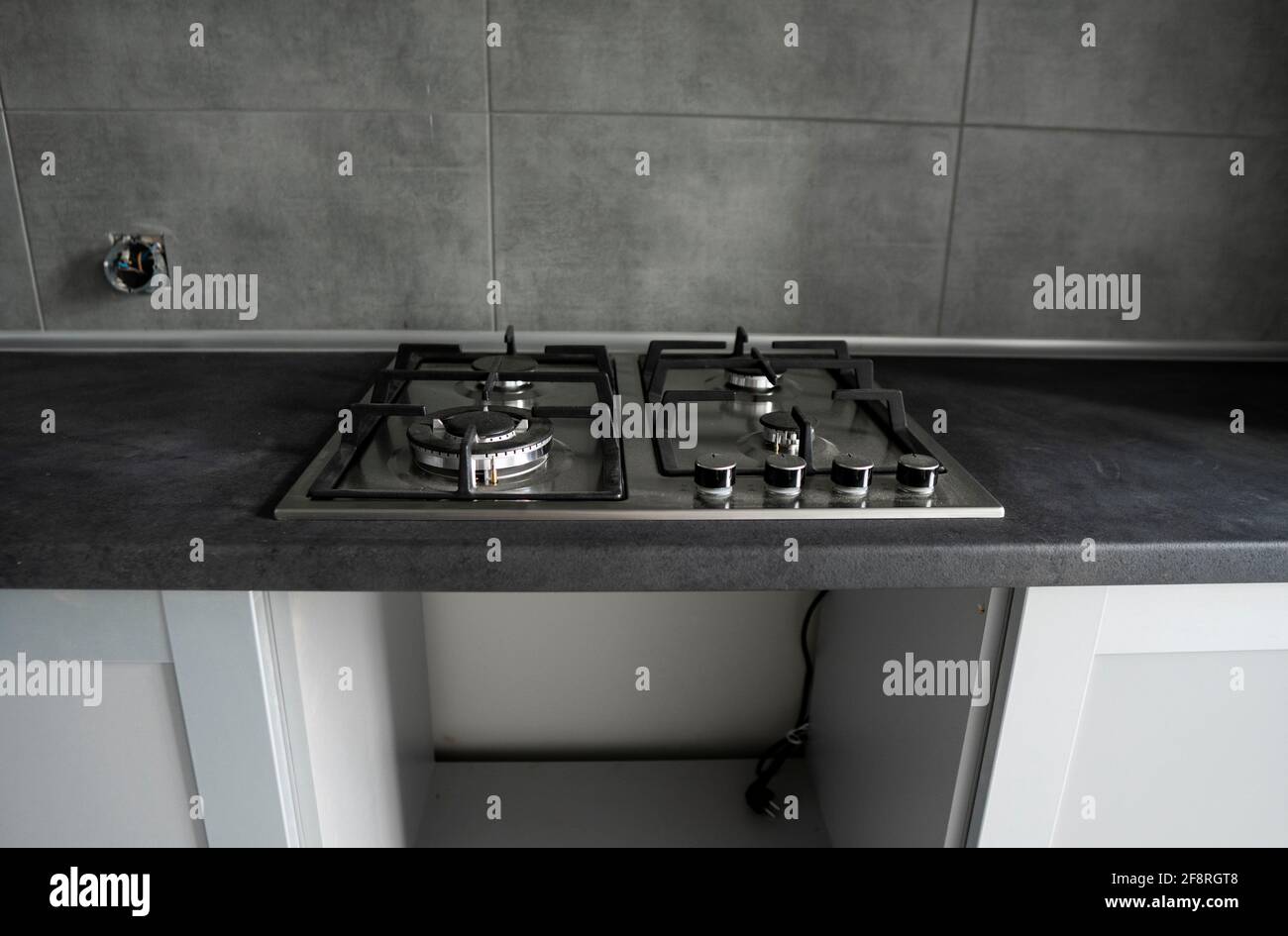 Stainless grey metal kitchen gas stove installed on a the kitchen with ...