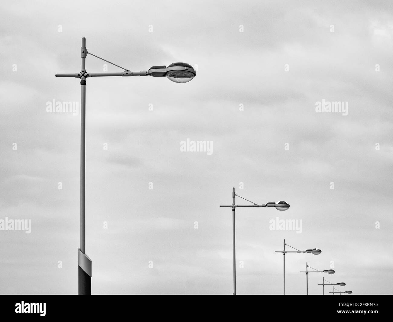 Row of street lights on a cloudy day Stock Photo - Alamy
