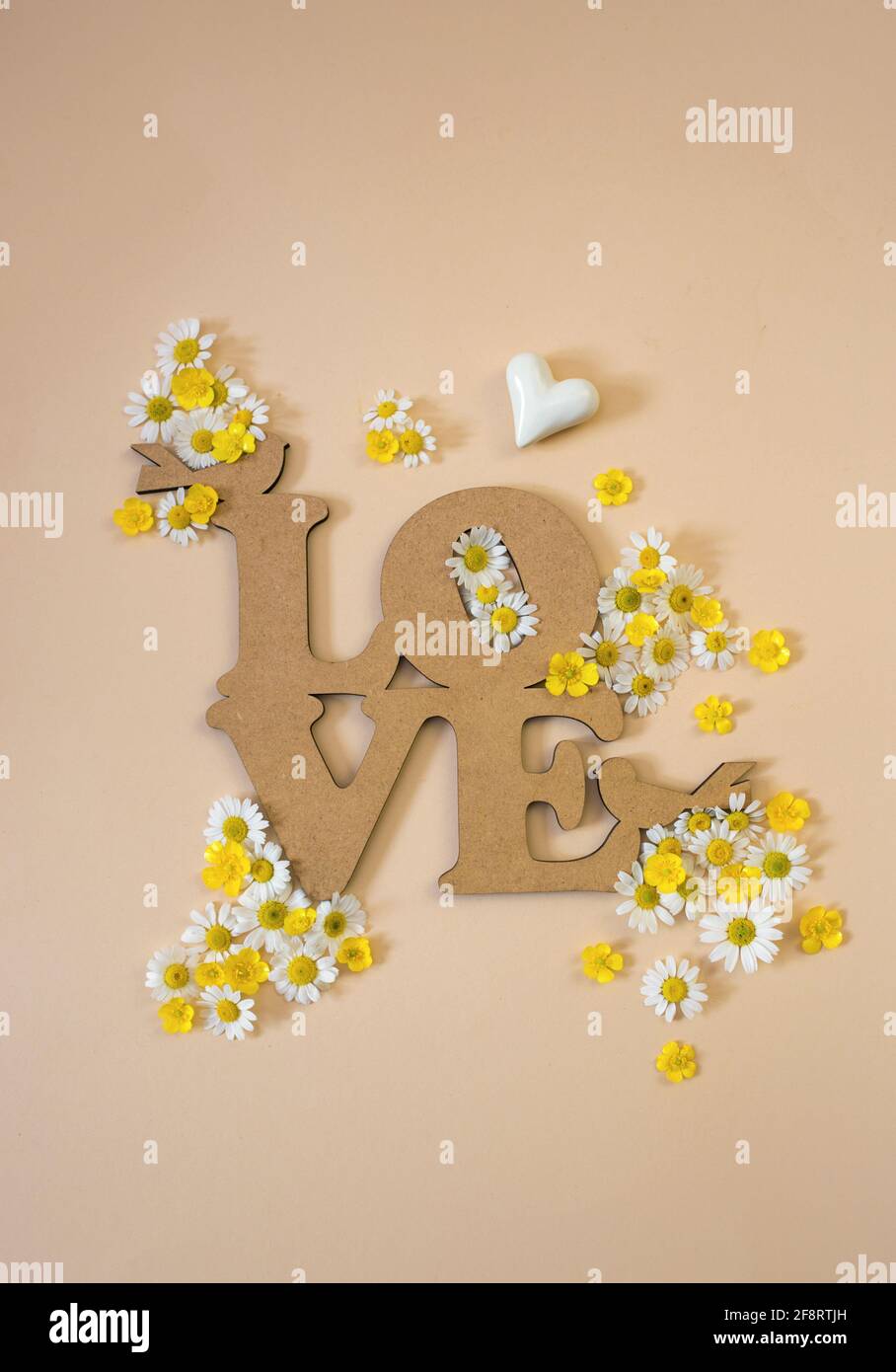 On a beige background, the word love is surrounded by small flowers of ...