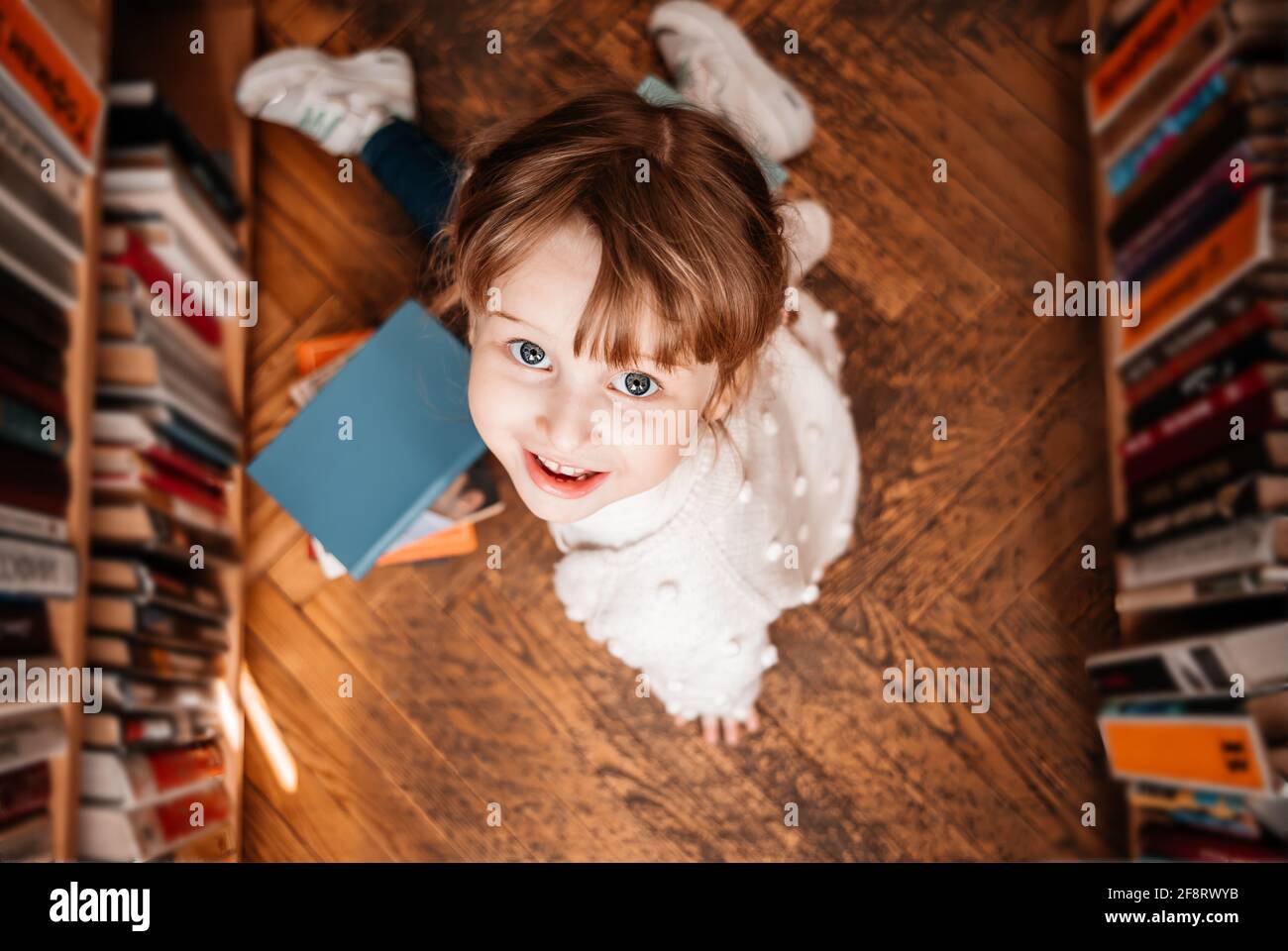 Baby girl in the library with books in her hands. cute toddler explores ...