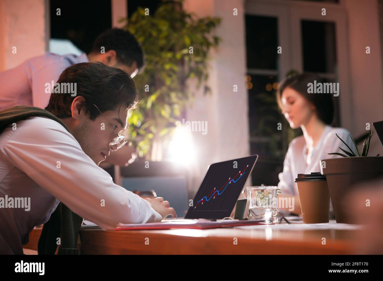 Colleagues working together in modern office using devices and gadgets ...