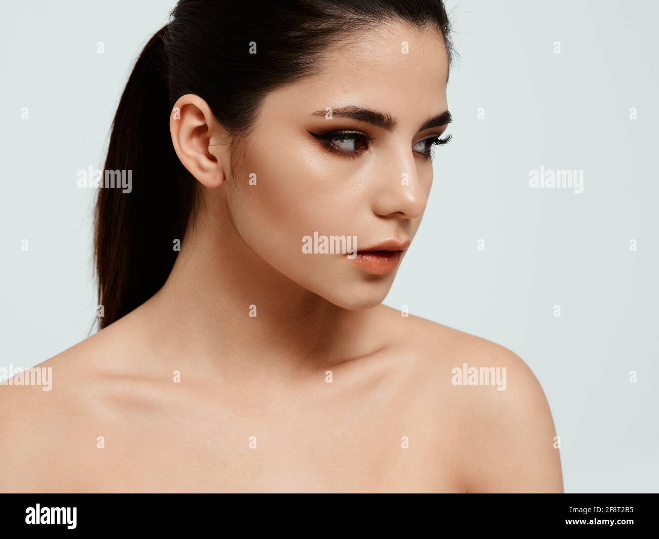 Side view of beautiful lady with evening makeup on her face and light ...