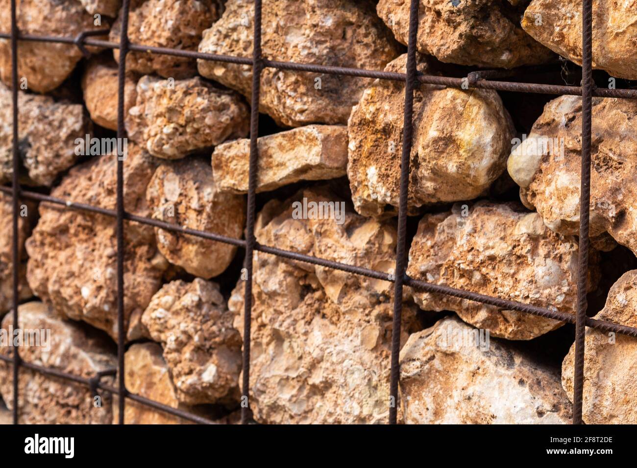 Background and texture of many rough stones in a metal cage forming a ...