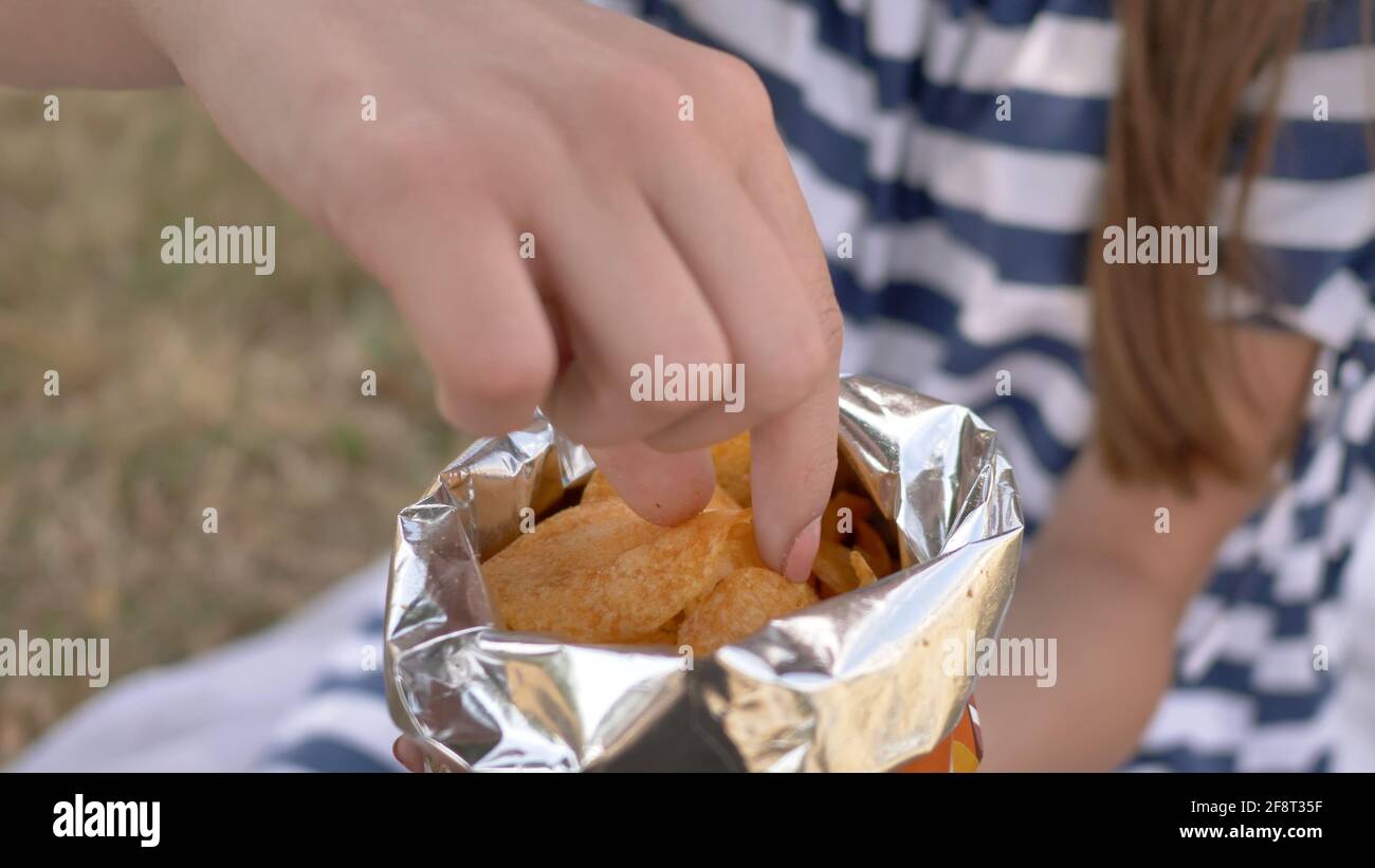The Girl Eats Chips In The City Park In The Summer The Girl Eats Chips