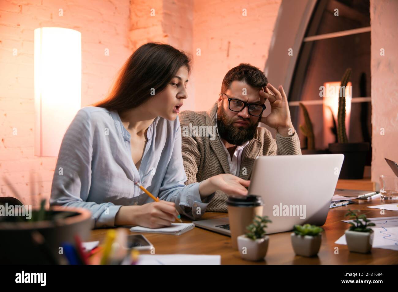 Colleagues working together in modern office using devices and gadgets ...