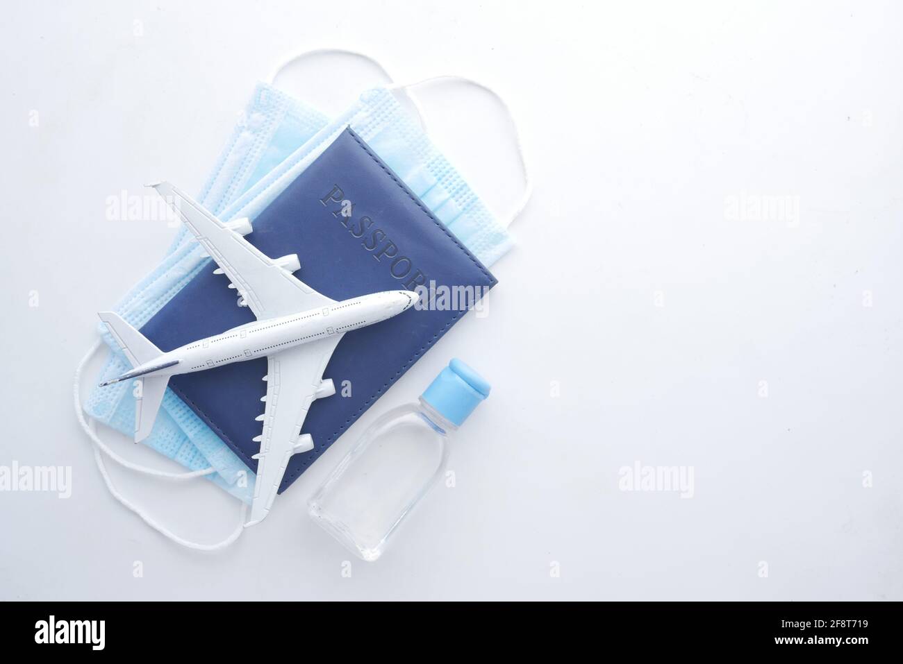 protective mask, airplane and blue color passport on table Stock Photo ...