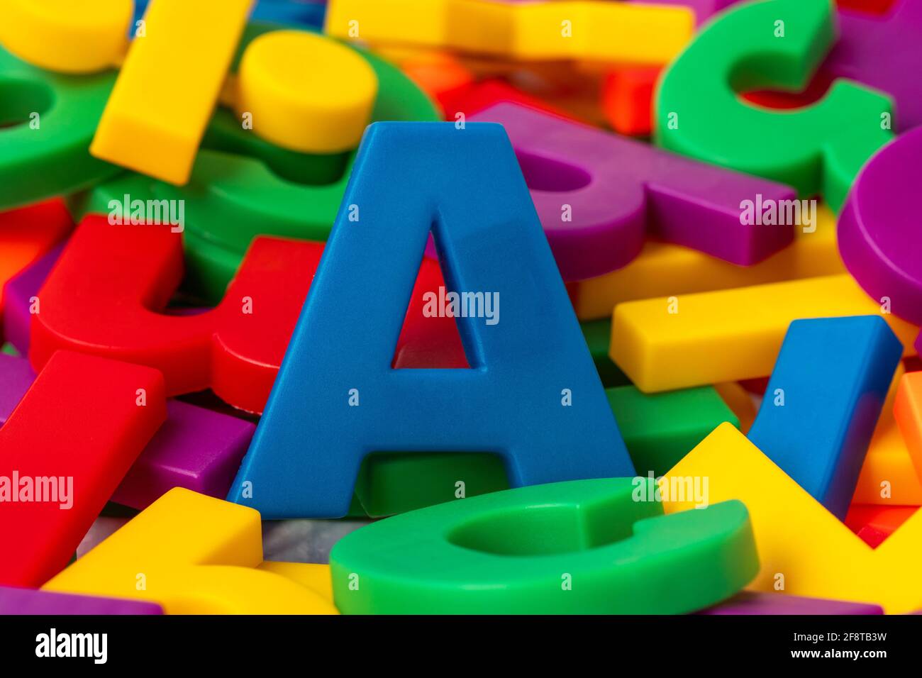 Blue letter "A" on the pile of colorful plastic letters Stock Photo - Alamy