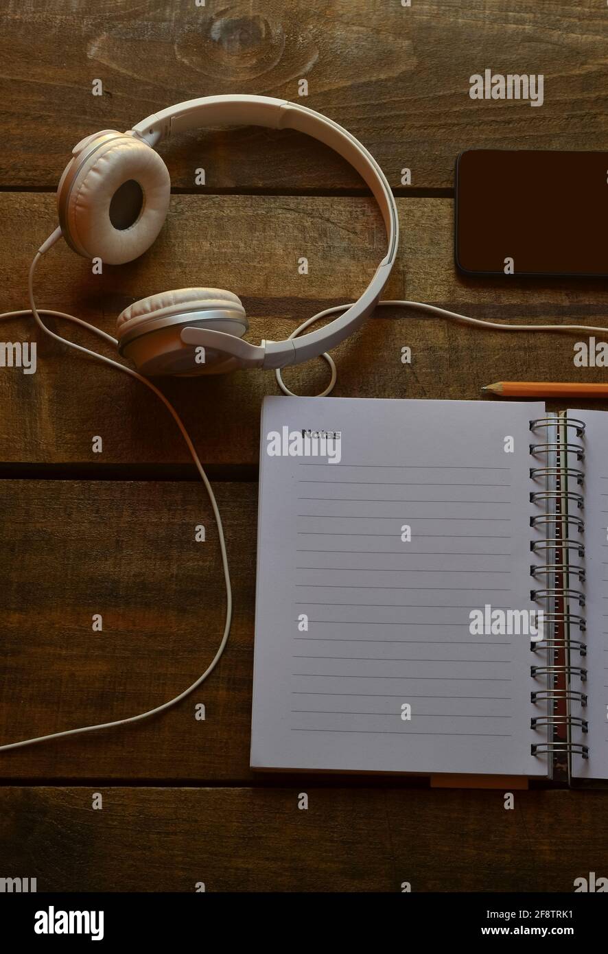 notebook to write with headphones and cell phone on wood to write ideas ...