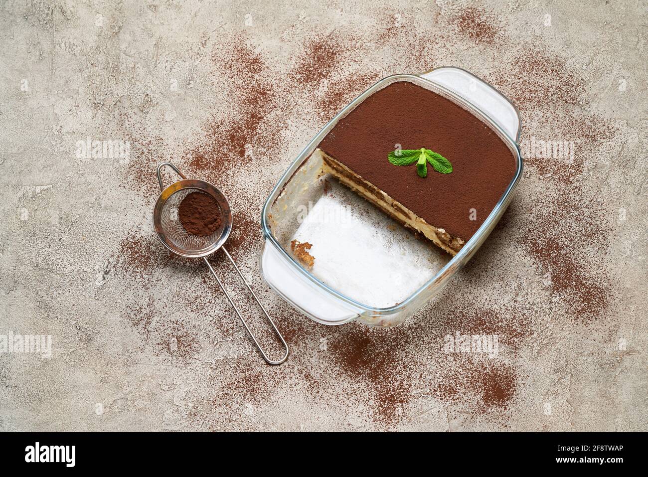 Traditional Italian Tiramisu dessert in glass baking dish on grey concrete background Stock ...