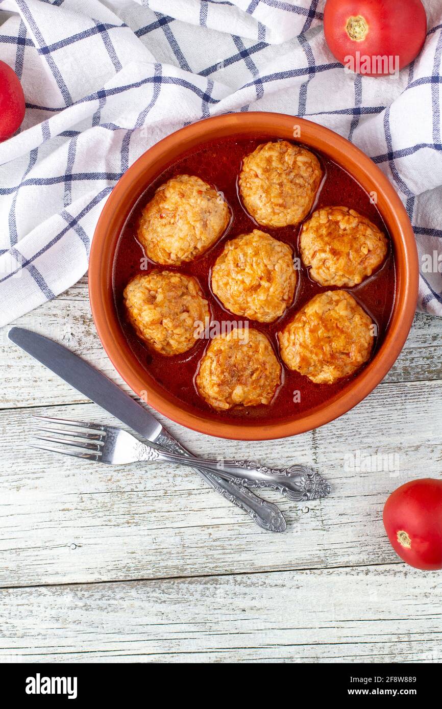 Meatballs in tomato sauce in a bowl on wooden table. Tasty dinner food. Top view copy space ...