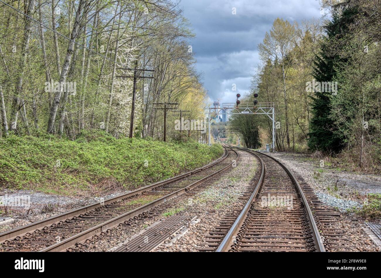 Curve of rail road pathways leading to a city Stock Photo - Alamy