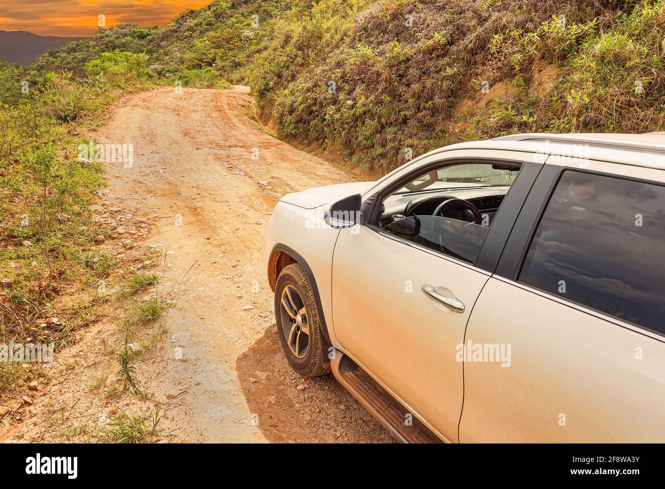 SUV car going up the sierra on a rocky road, white car on sloping ...