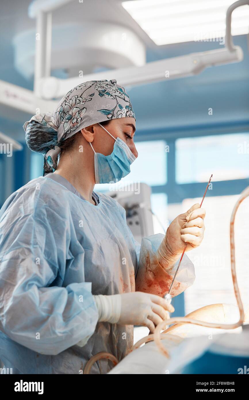 cosmetic liposuction surgery in actual operating room setting showing ...