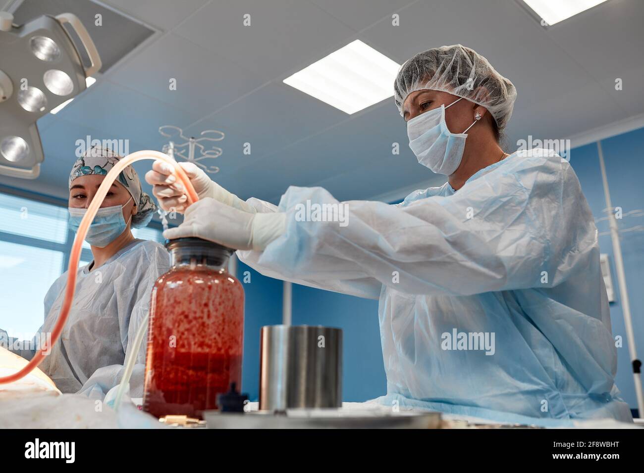 cosmetic liposuction surgery in actual operating room setting showing ...