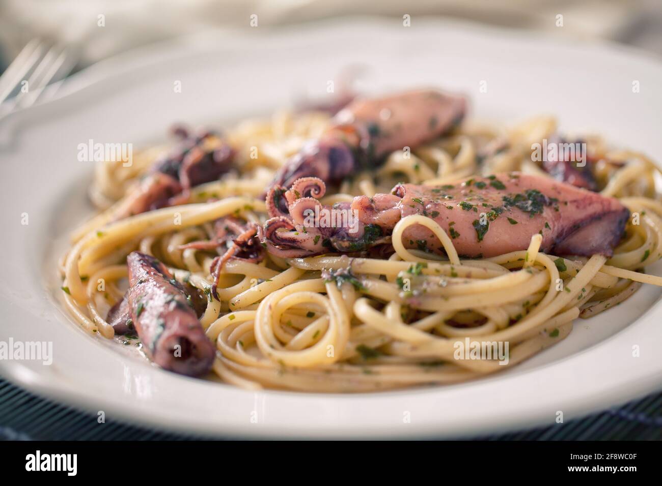 Seafood spaghetti with fresh calamari and parsley Stock Photo - Alamy