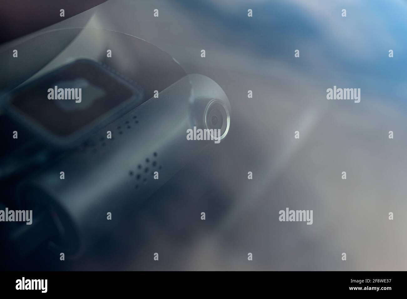 A modern car camera is attached to the inside of the windshield, under ...