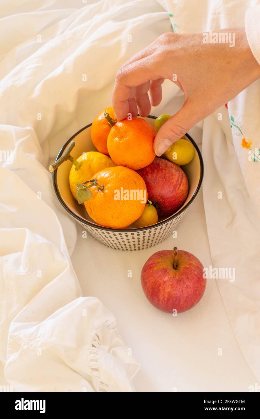 Bowl full of fresh fruits on a bed Stock Photo - Alamy