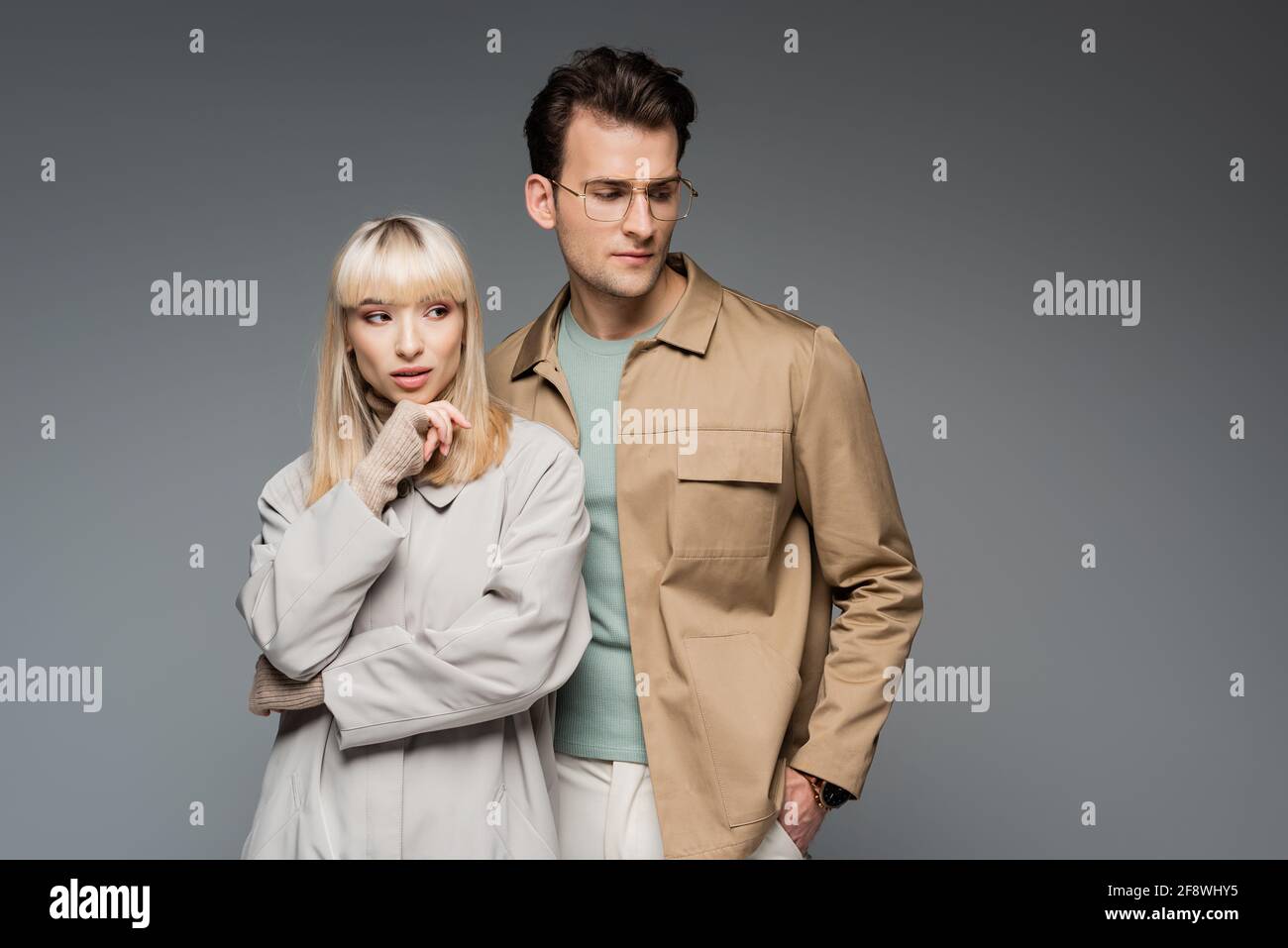 trendy models posing while standing isolated on grey Stock Photo - Alamy