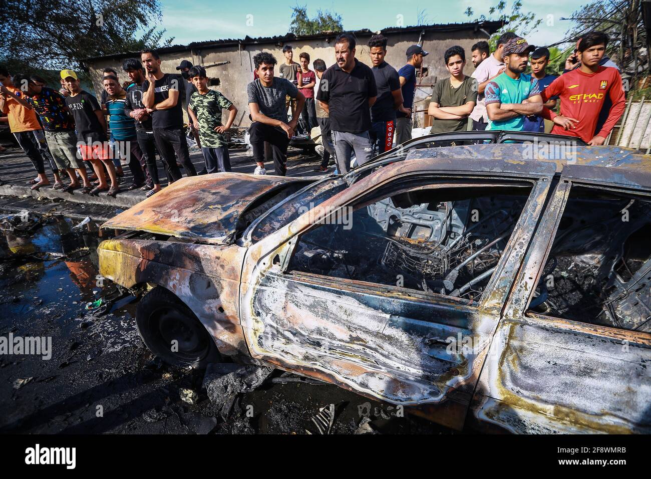 Baghdad, Iraq. 15th Apr, 2021. People inspect a destroyed vehicle at ...