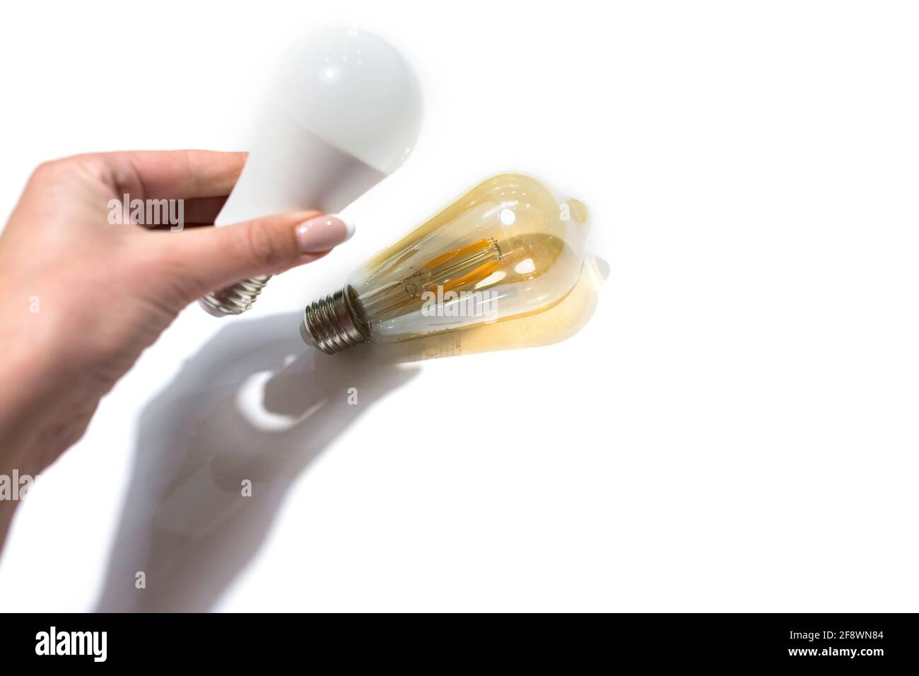 Electric diode light bulb in hand, isolated on white studio background ...