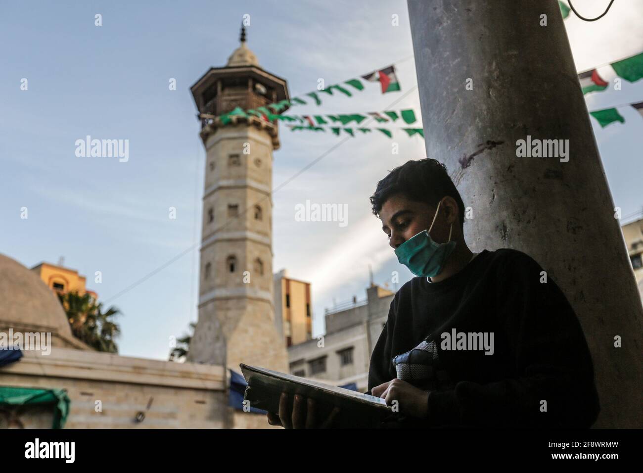 A Muslim young man reads a copy of the Holy Qur’an at the Medieval Al-Sayed Hashem Mosque in ...