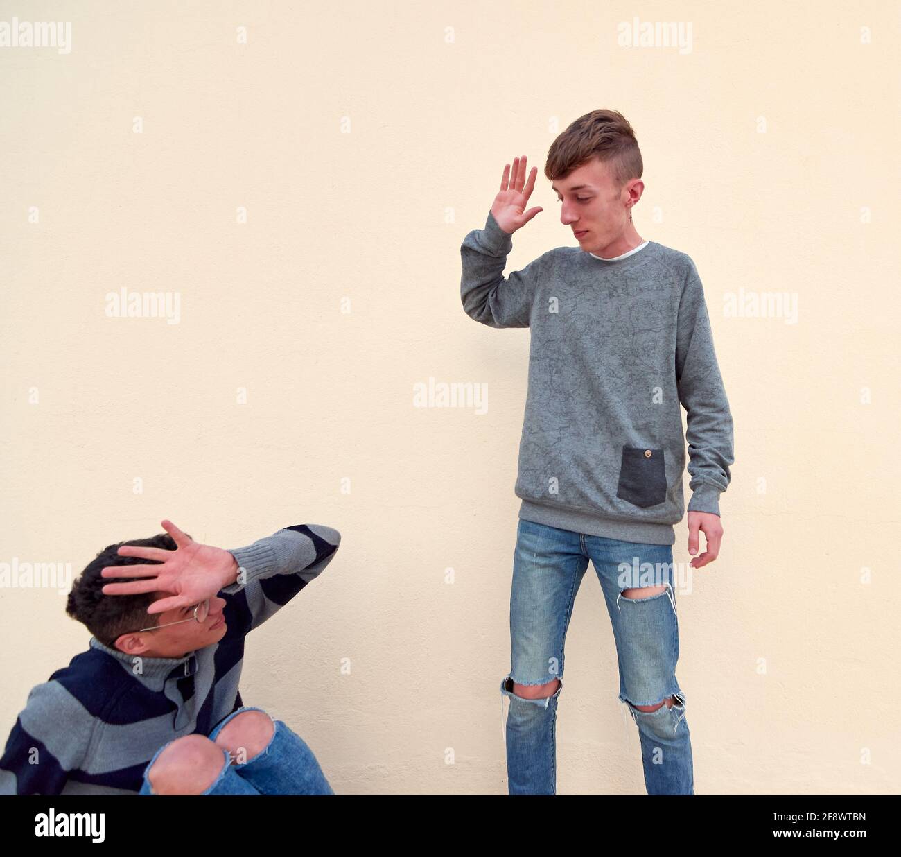 Young male bully threatening to hit a crouched scared male Stock Photo ...