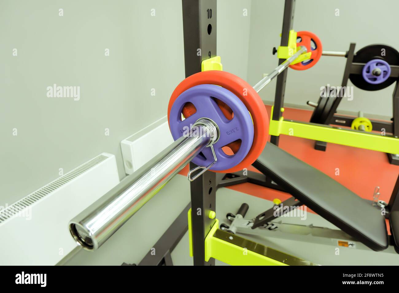 a barbell with weights for fitness lies in the gym on an adjustable ...