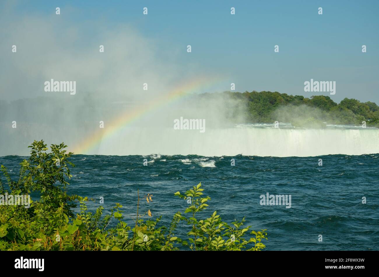View over the edge of the Canadian Niagara Falls with a rainbow in the ...
