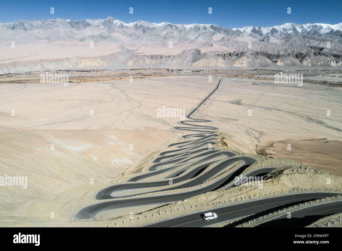 aerial view of the mountain road full of hairpin bends that connect ...