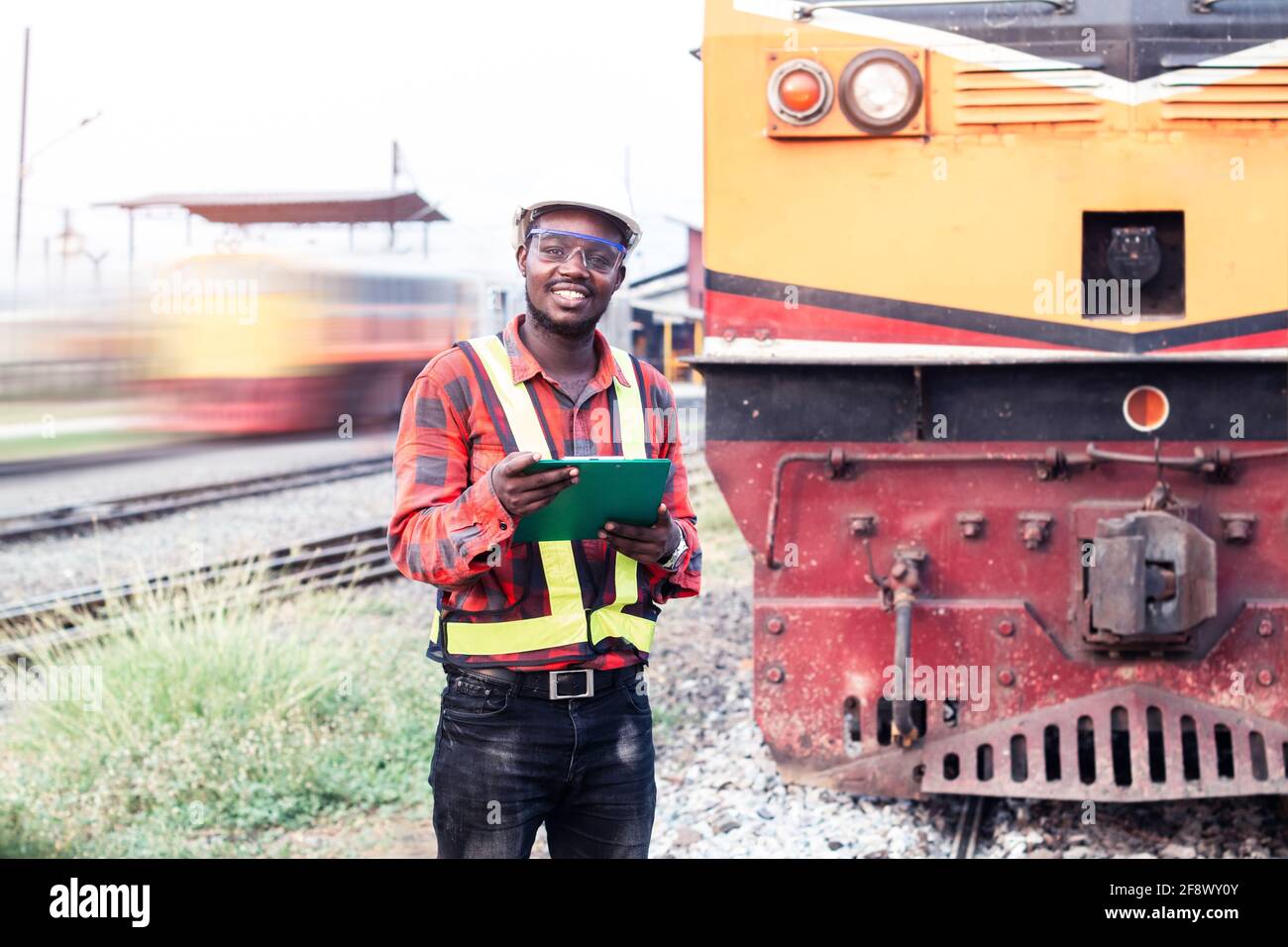 African man engineer looking report of Train Timetables for control a ...
