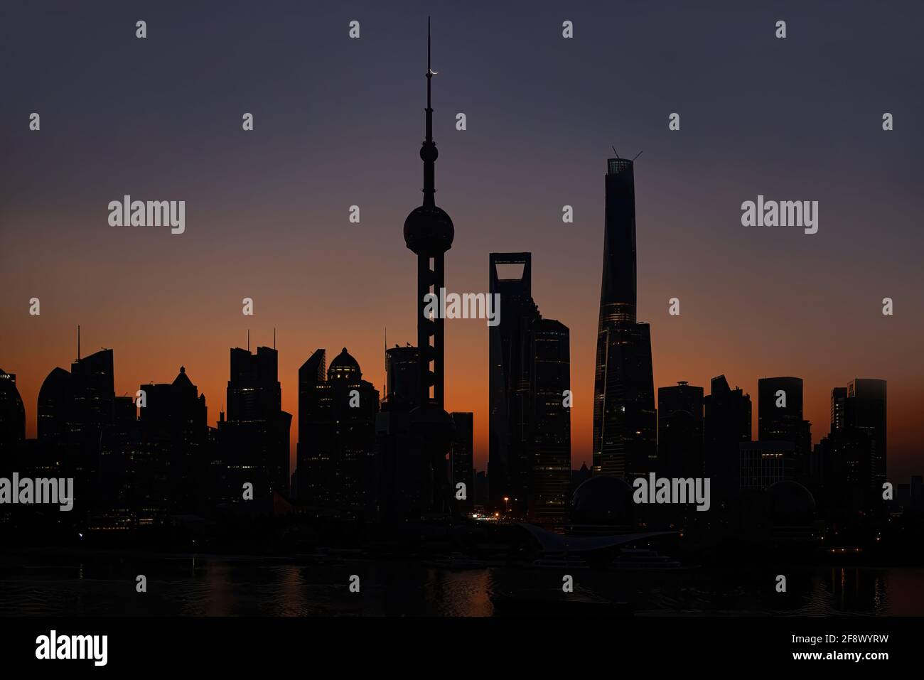 The sun rises behind the magnificent skyline of Shanghai creating ...