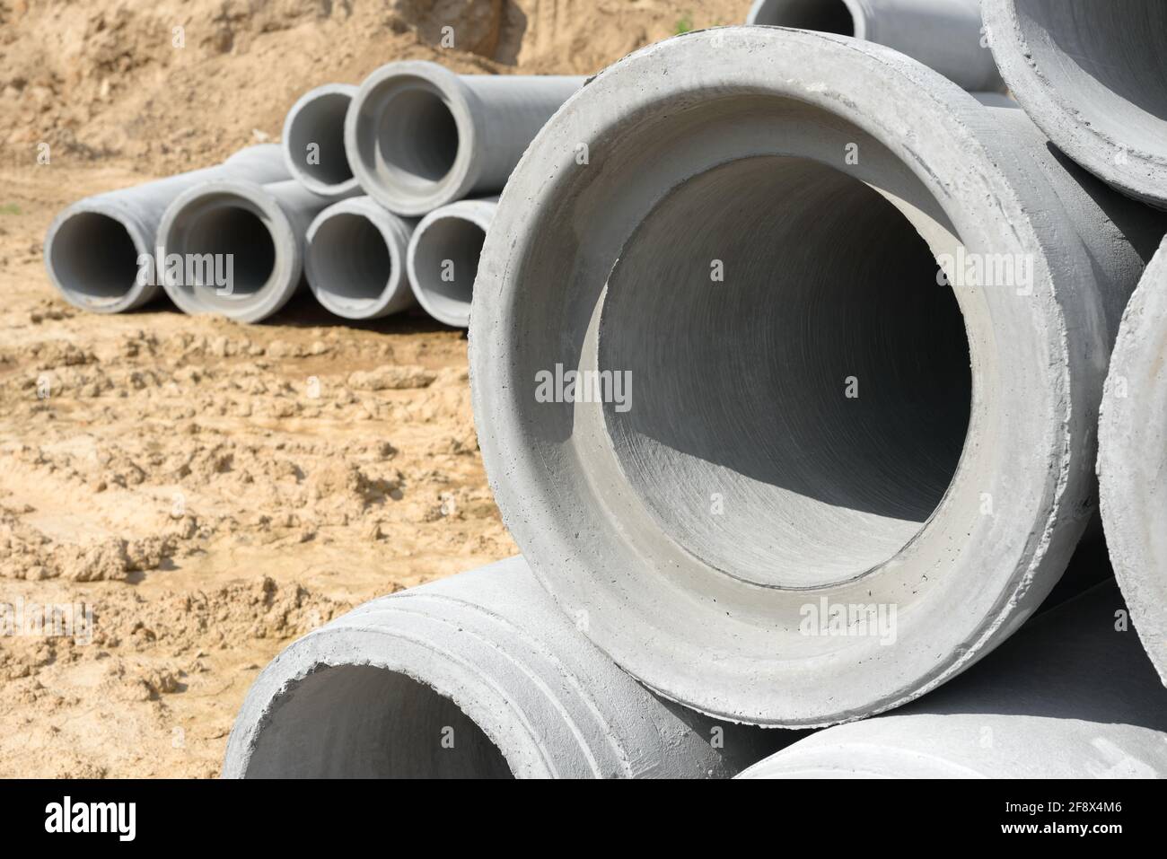 Industrial concrete drainage pipes stacked for construction. New tubes ...
