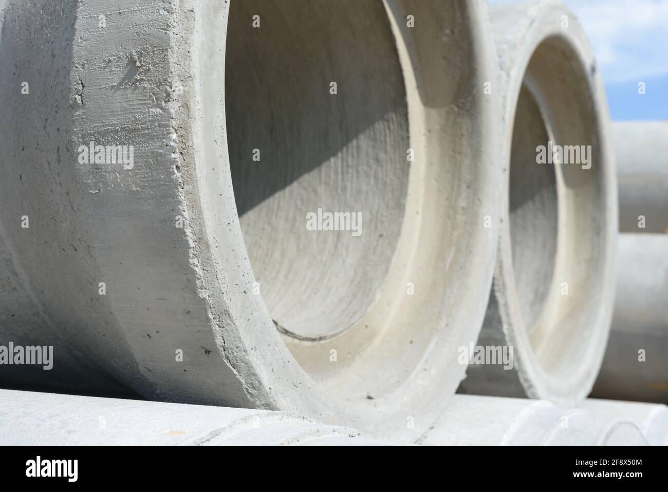Industrial concrete drainage pipes stacked for construction. New tubes ...