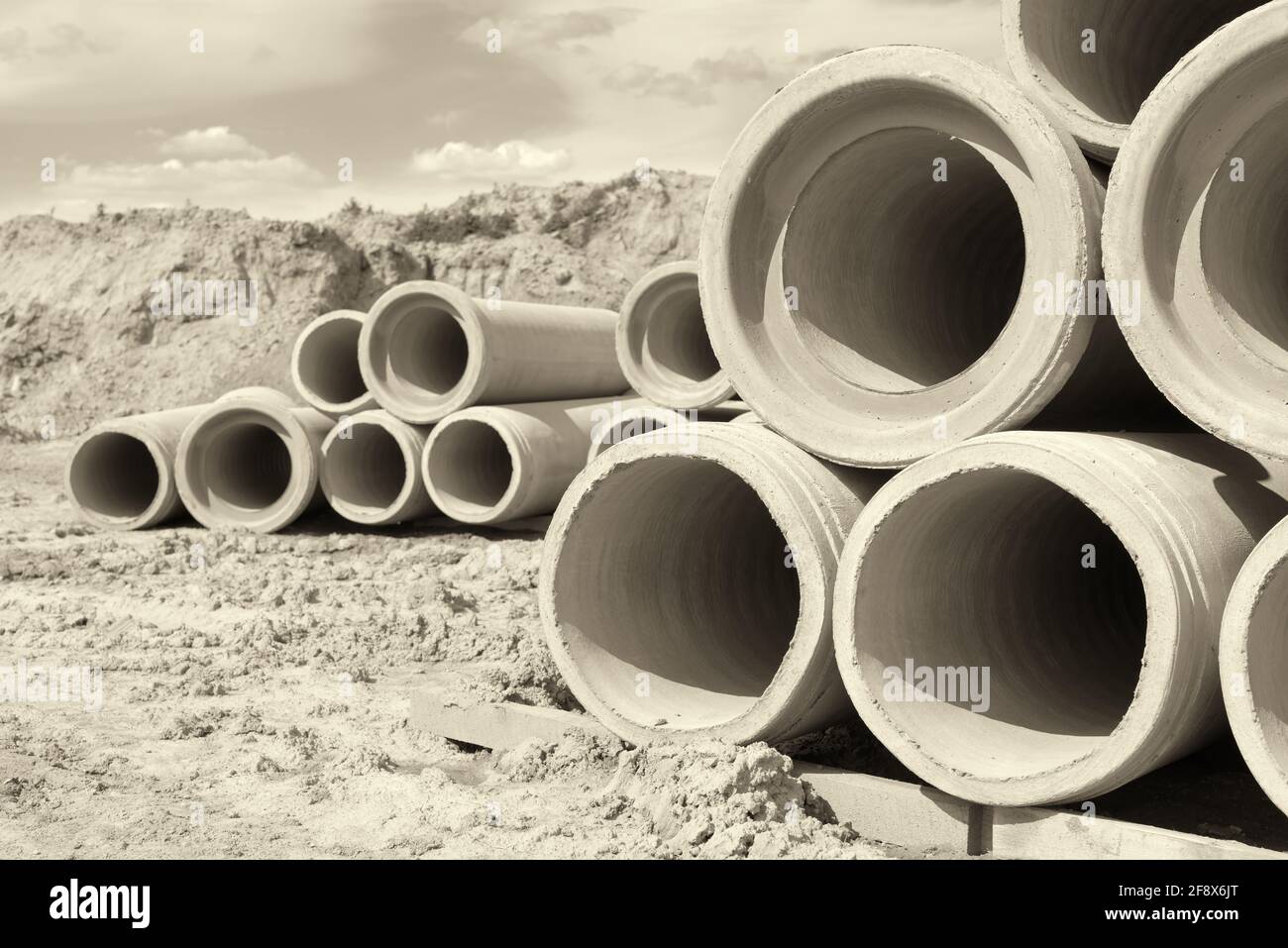 Industrial concrete drainage pipes stacked for construction. New tubes ...