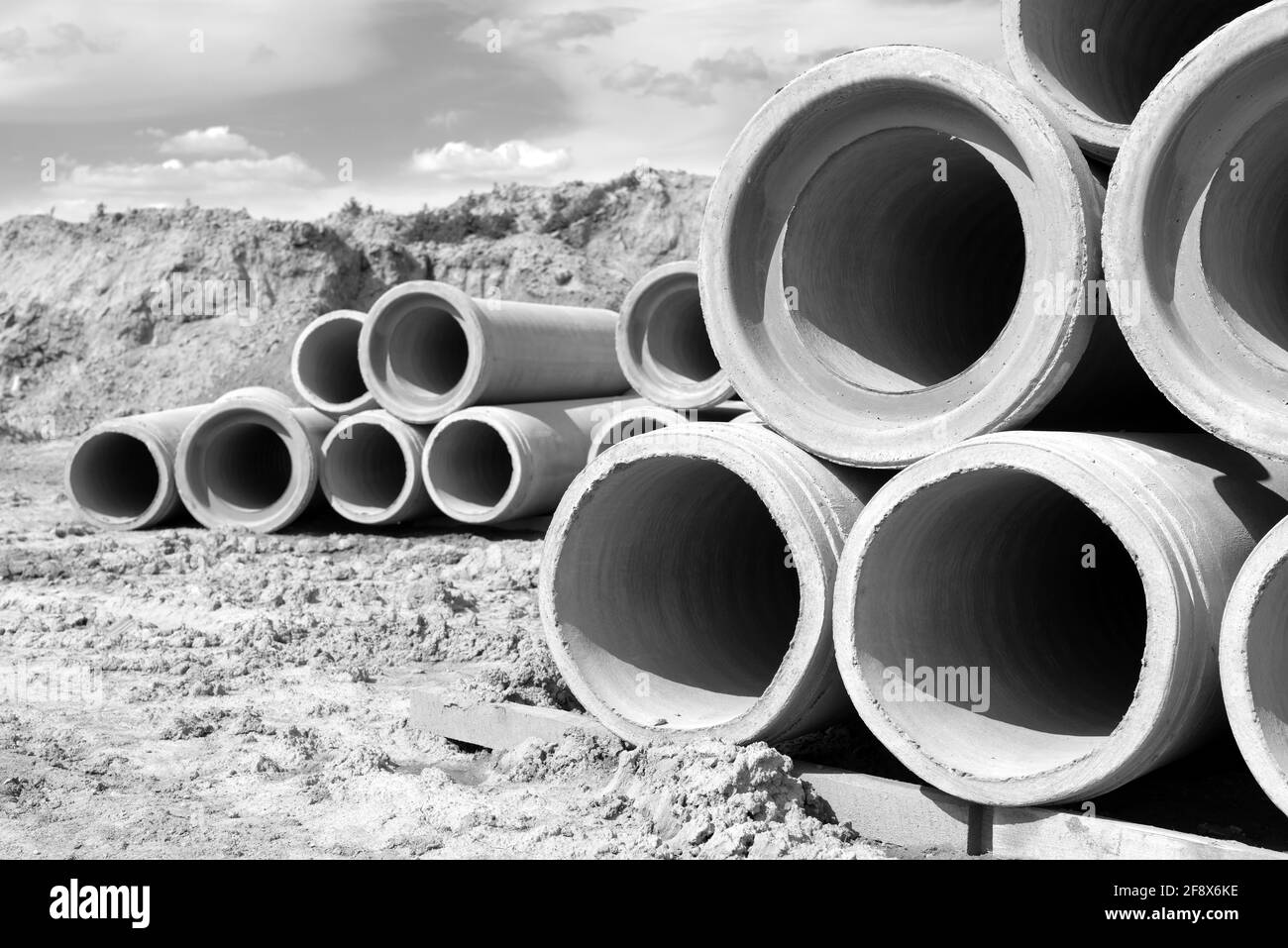 Industrial concrete drainage pipes stacked for construction. New tubes ...