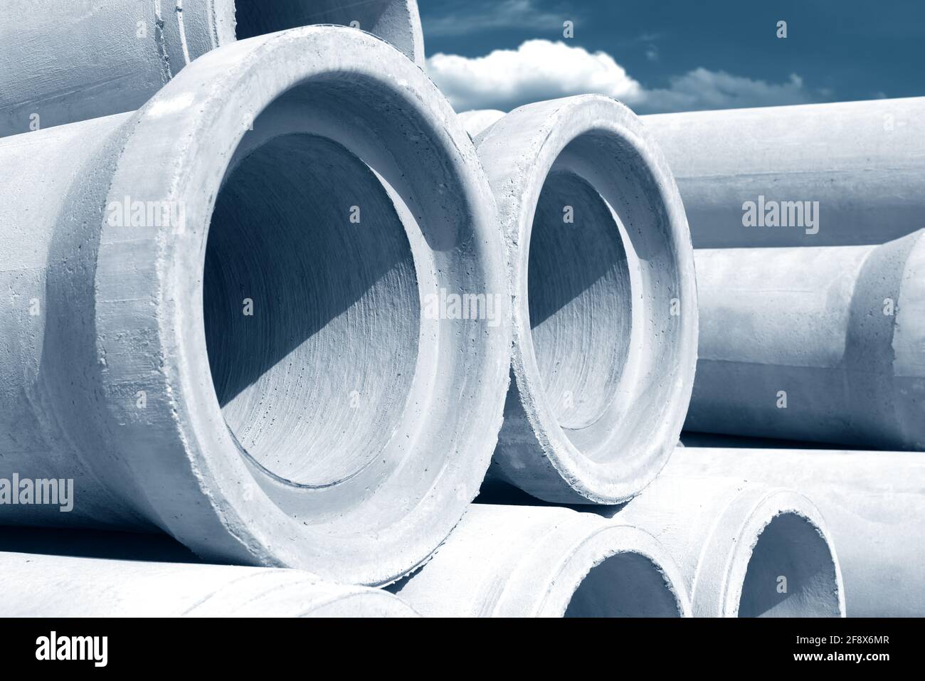 Industrial concrete drainage pipes stacked for construction. New tubes ...