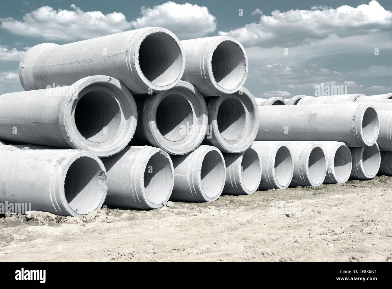 Industrial concrete drainage pipes stacked for construction. New tubes ...