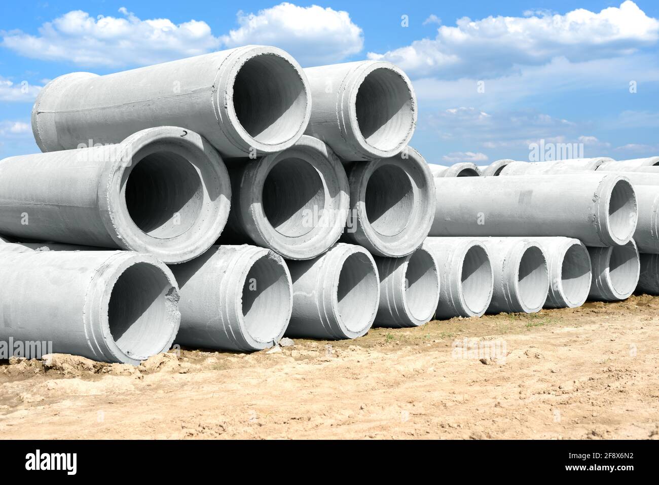 Industrial concrete drainage pipes stacked for construction. New tubes ...