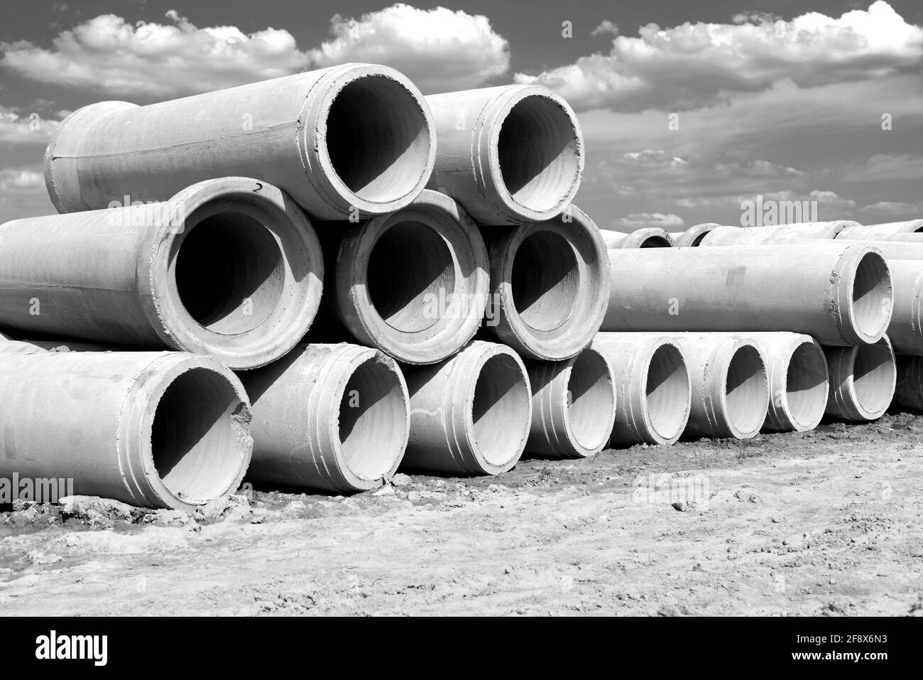 Industrial concrete drainage pipes stacked for construction. New tubes ...