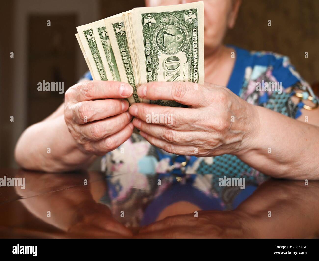 An elderly woman counts dollars. Last money for life, low incomes ...