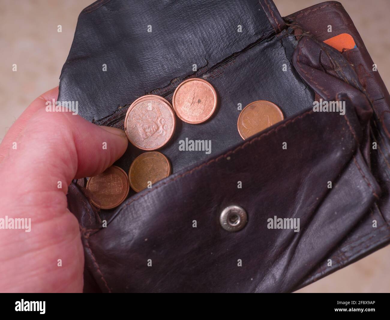 Hands Holding A Empty Wallet With A Few Cent Coins Stock Photo - Alamy